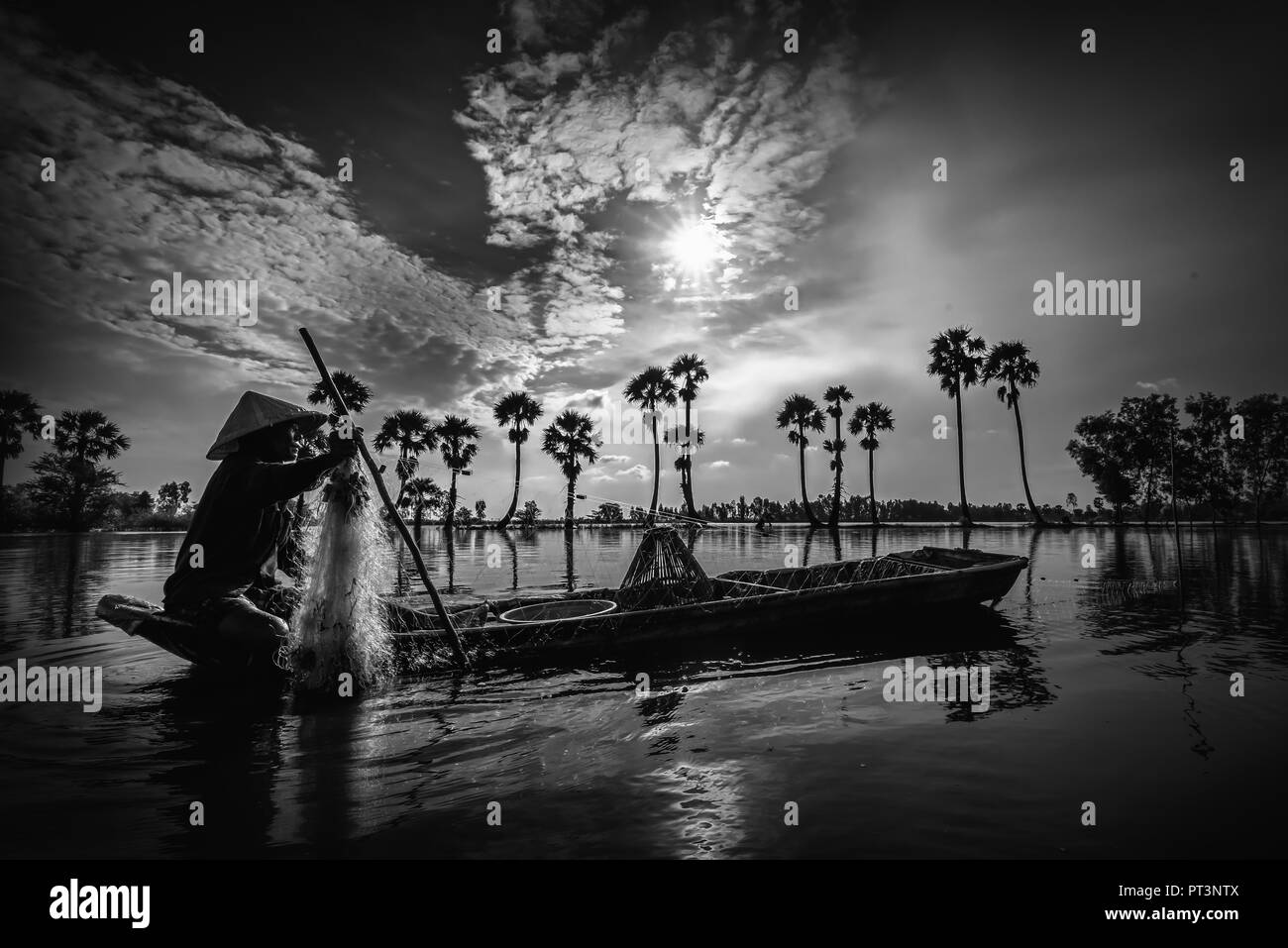 Unidentified fishers spread a net to catch fish in a lake when sunrises ...