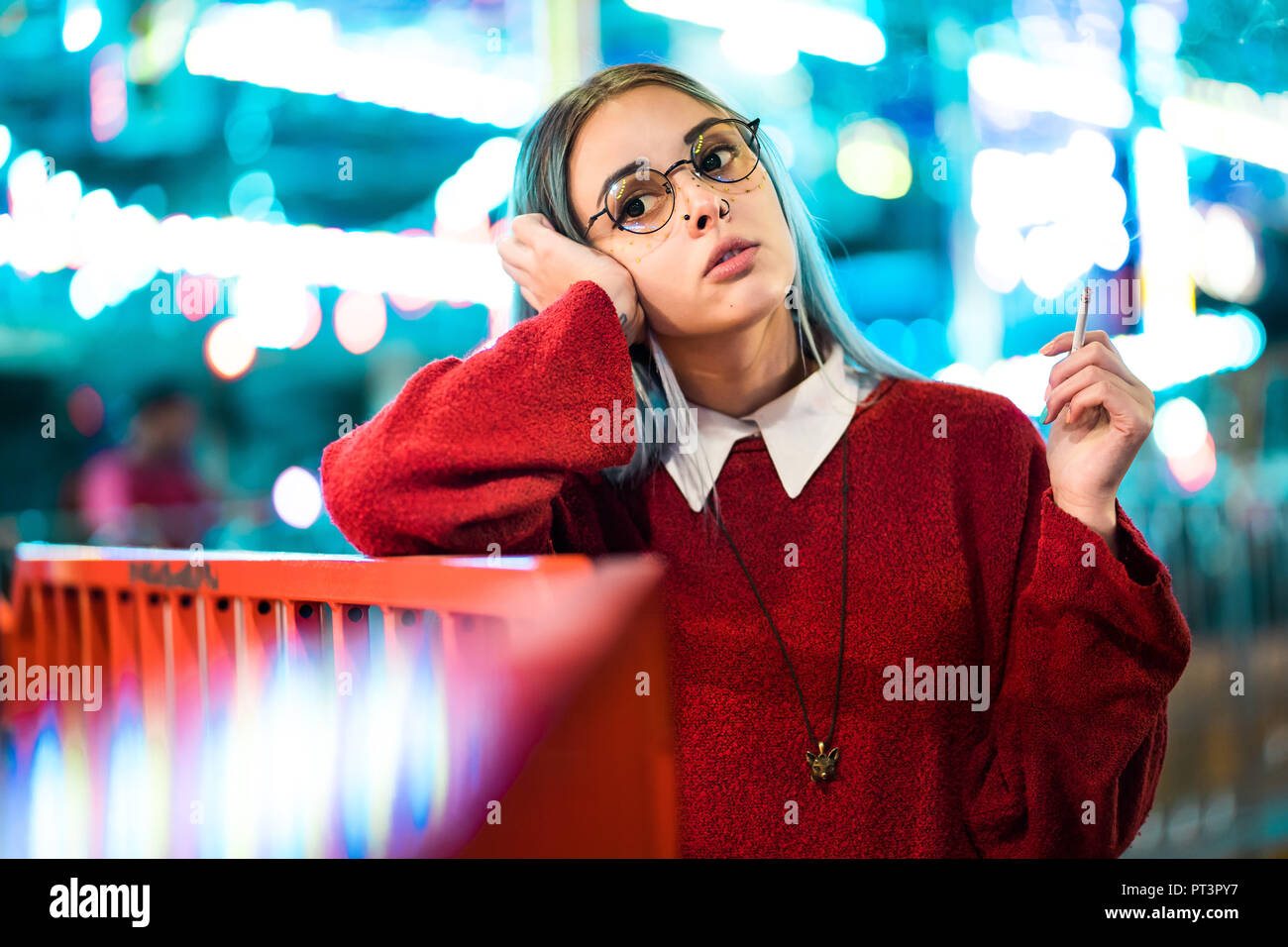 Millennial pretty girl with unusual dyed hairstyle smoking cigarette in ...