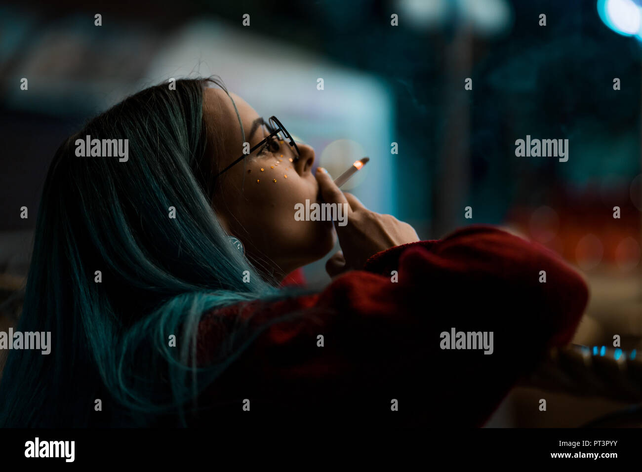 Millennial cool pretty girl with unusual dyed hairstyle smoking ...