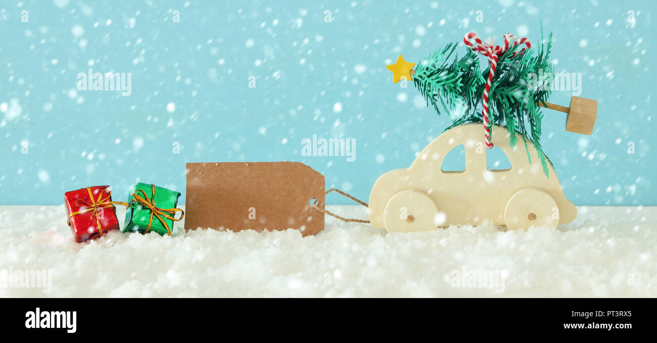 Wooden car carrying a christmas tree in front of blue background Stock ...