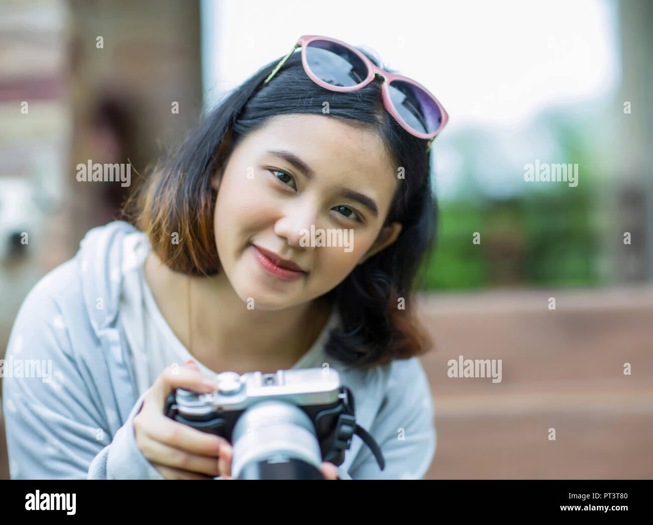 Young pretty asian woman holding camera with happiness Stock Photo - Alamy