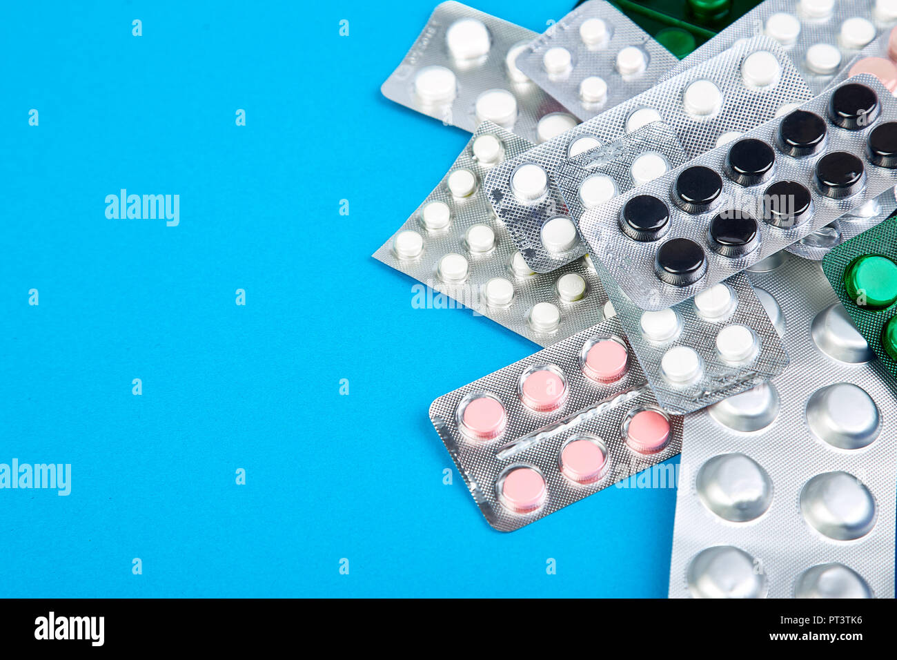 Pills, tablets and blister on blue background. Health care concept ...