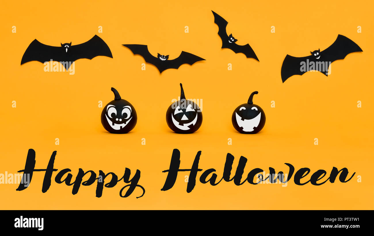 Cute Halloween pumpkins with funny smiling faces and paper bats flying ...