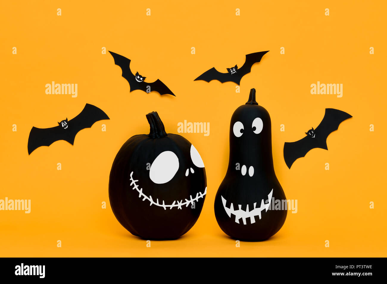 Cute Halloween pumpkins with funny smiling faces and paper bats flying ...