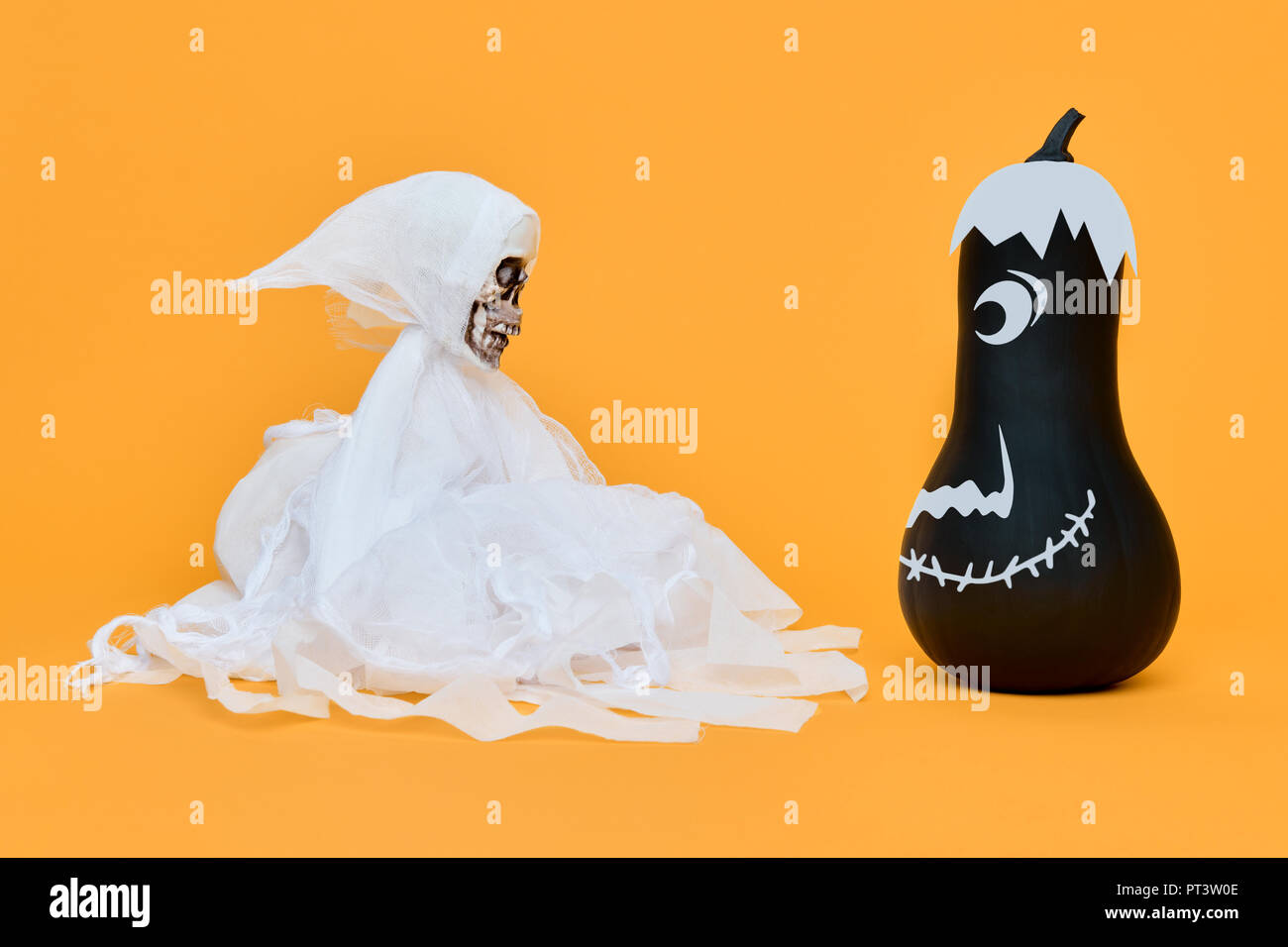 Spooky Halloween Concept. Scary skeleton face to face with cute smiling ...