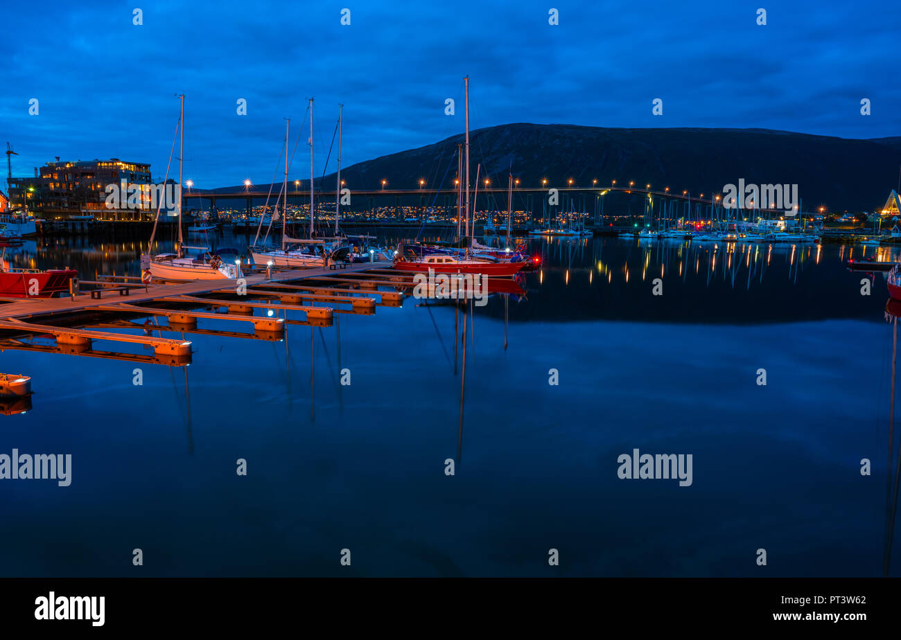 Night view of marina area in Tromso with Tromso Bridge in the distance ...
