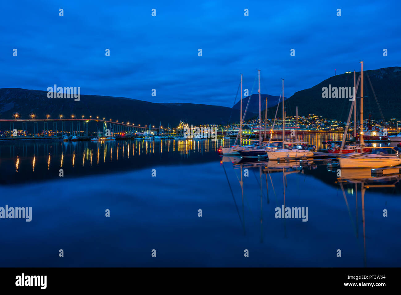 Night view of marina area in Tromso with Tromso Bridge in the distance ...