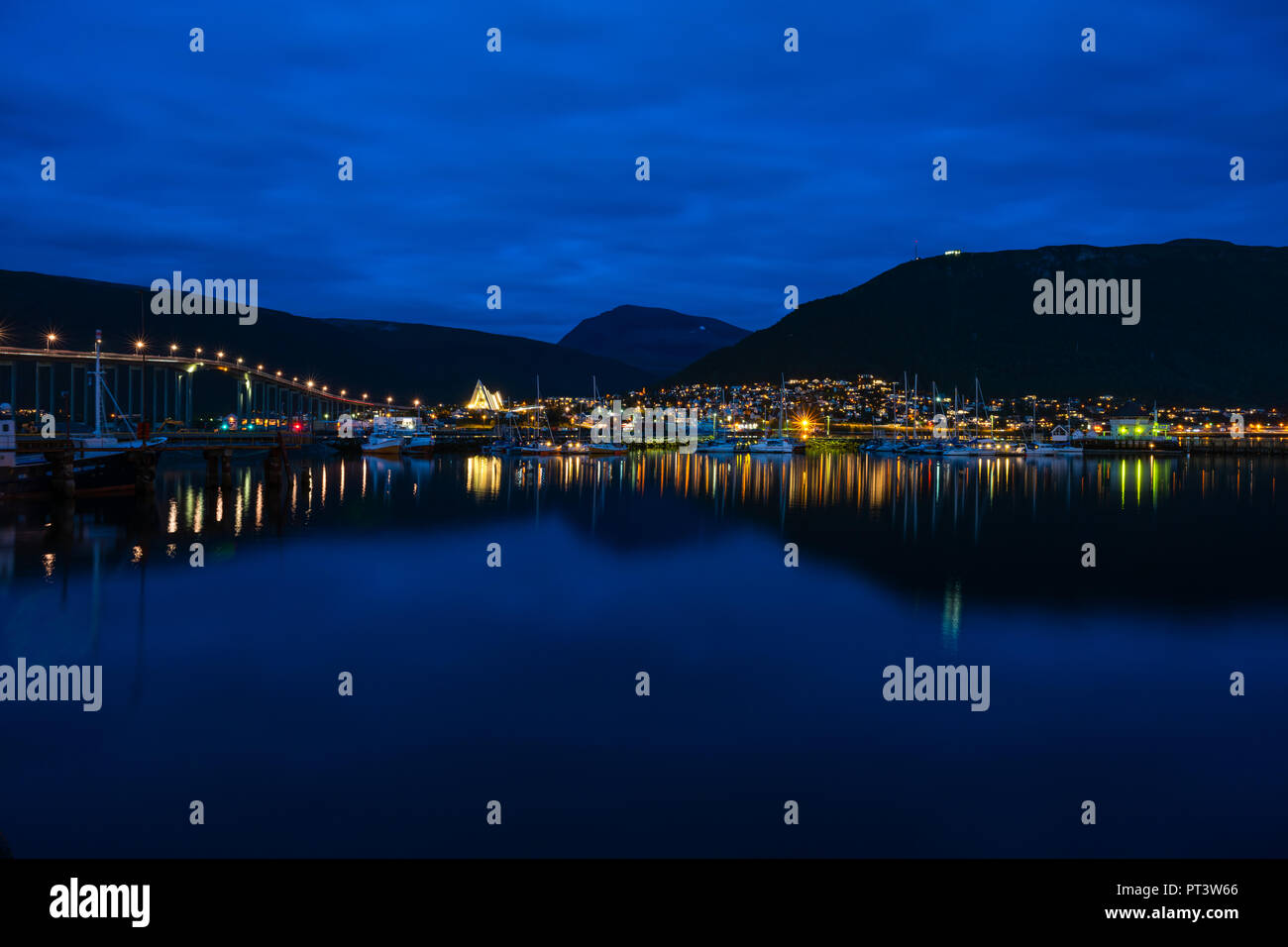 Night view of marina area in Tromso with Tromso Bridge in the distance ...
