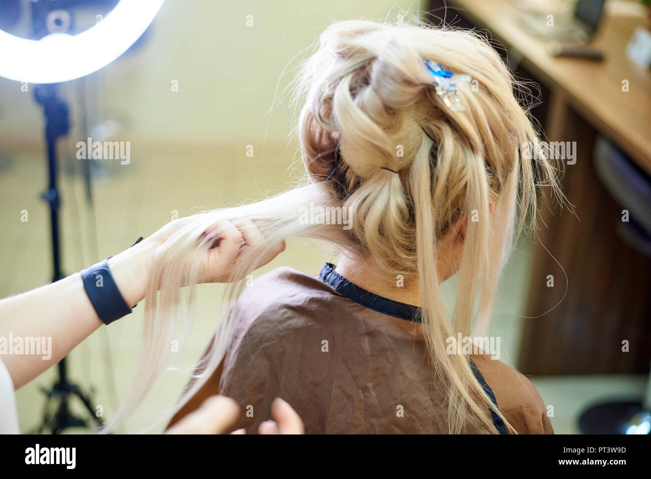 Hairdressing services.Сreating an evening hairstyle. Hair styling ...