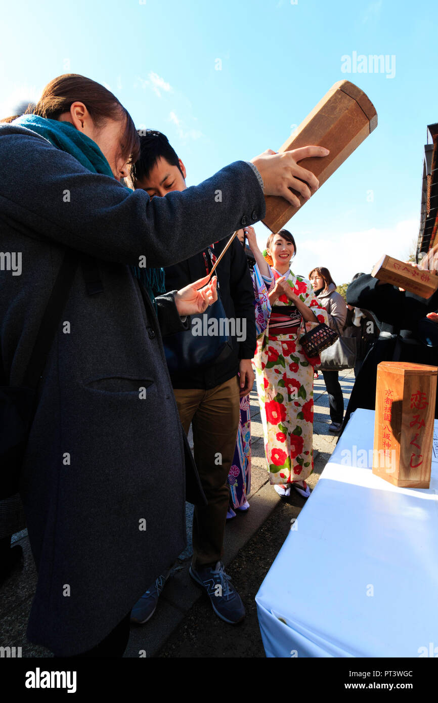 Man shaking omikuji boxes before taking out the paper fortune slip at ...
