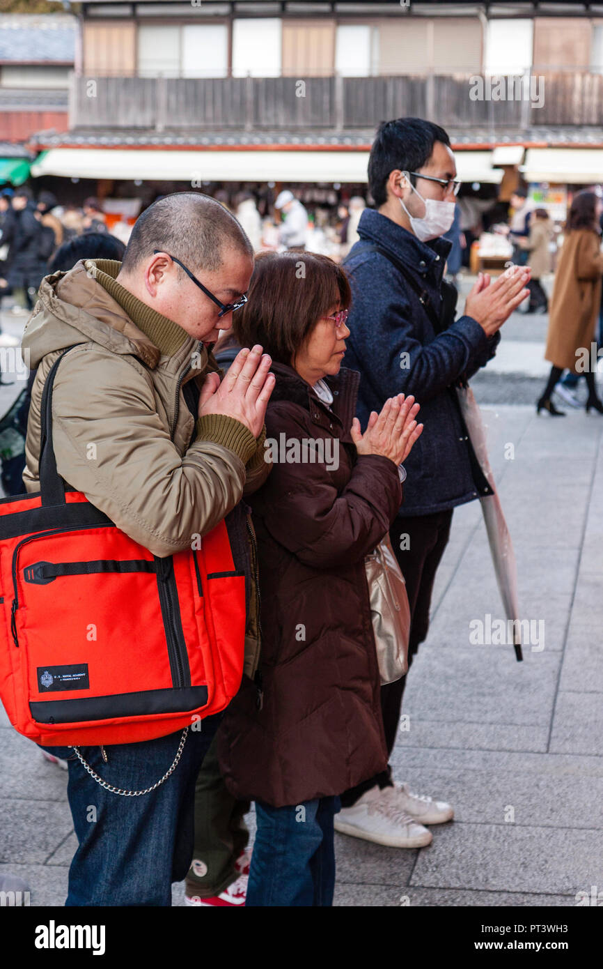 New Year, three people praying at the main stage of the Shinto Fushimi ...