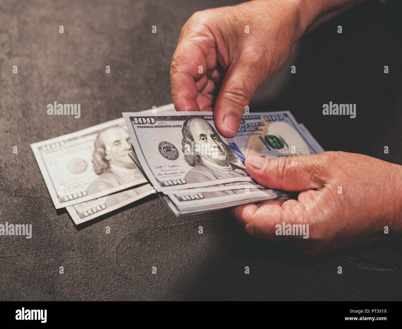 Counting US currency. Old woman counts money. New dollars in hands with wrinkles. Close up view ...