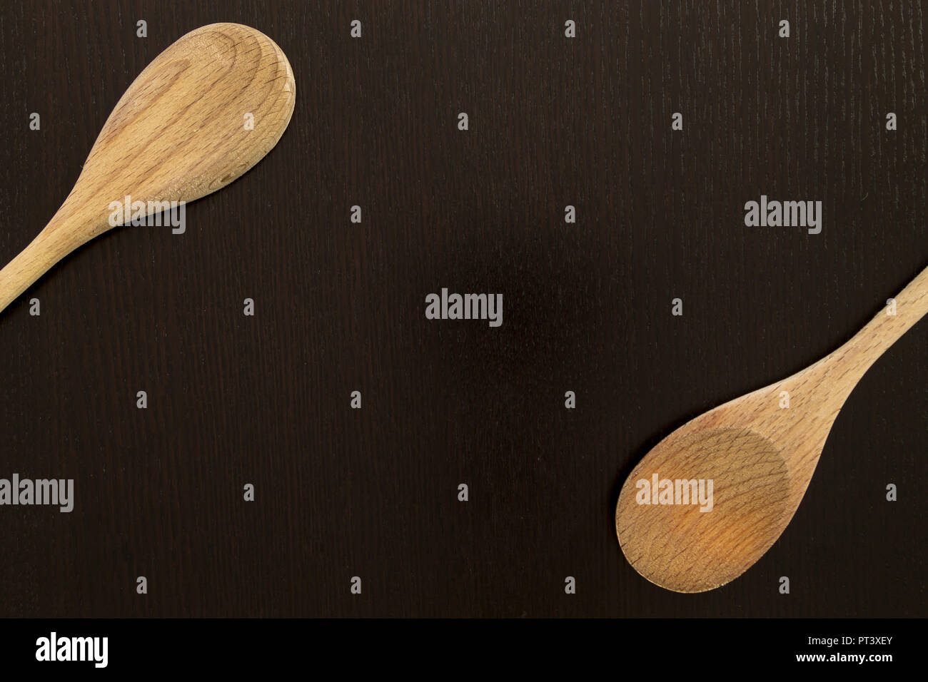 Wooden spoons on black table. Kitchen tools close up Stock Photo - Alamy