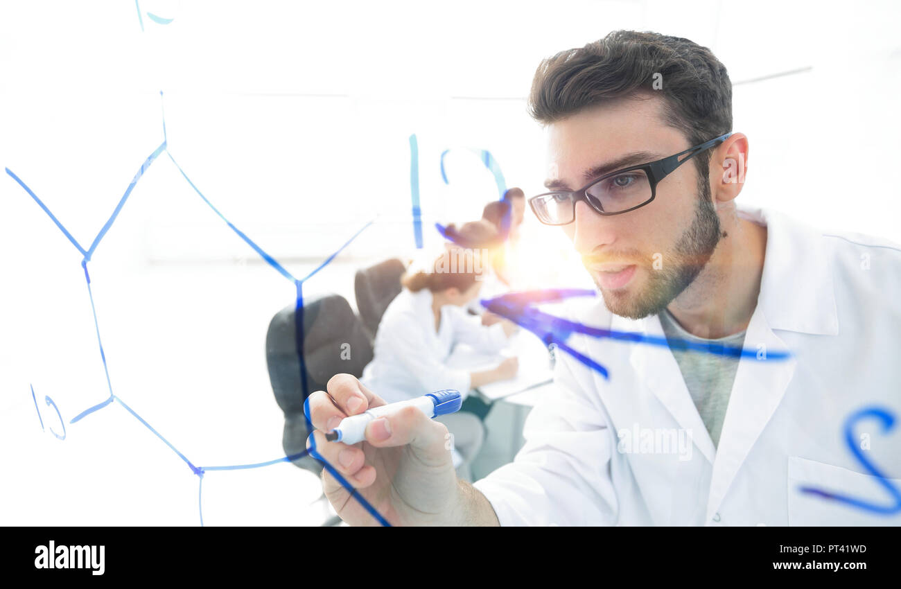 from behind the glass.scientist writes a marker on a glass Board.photo ...