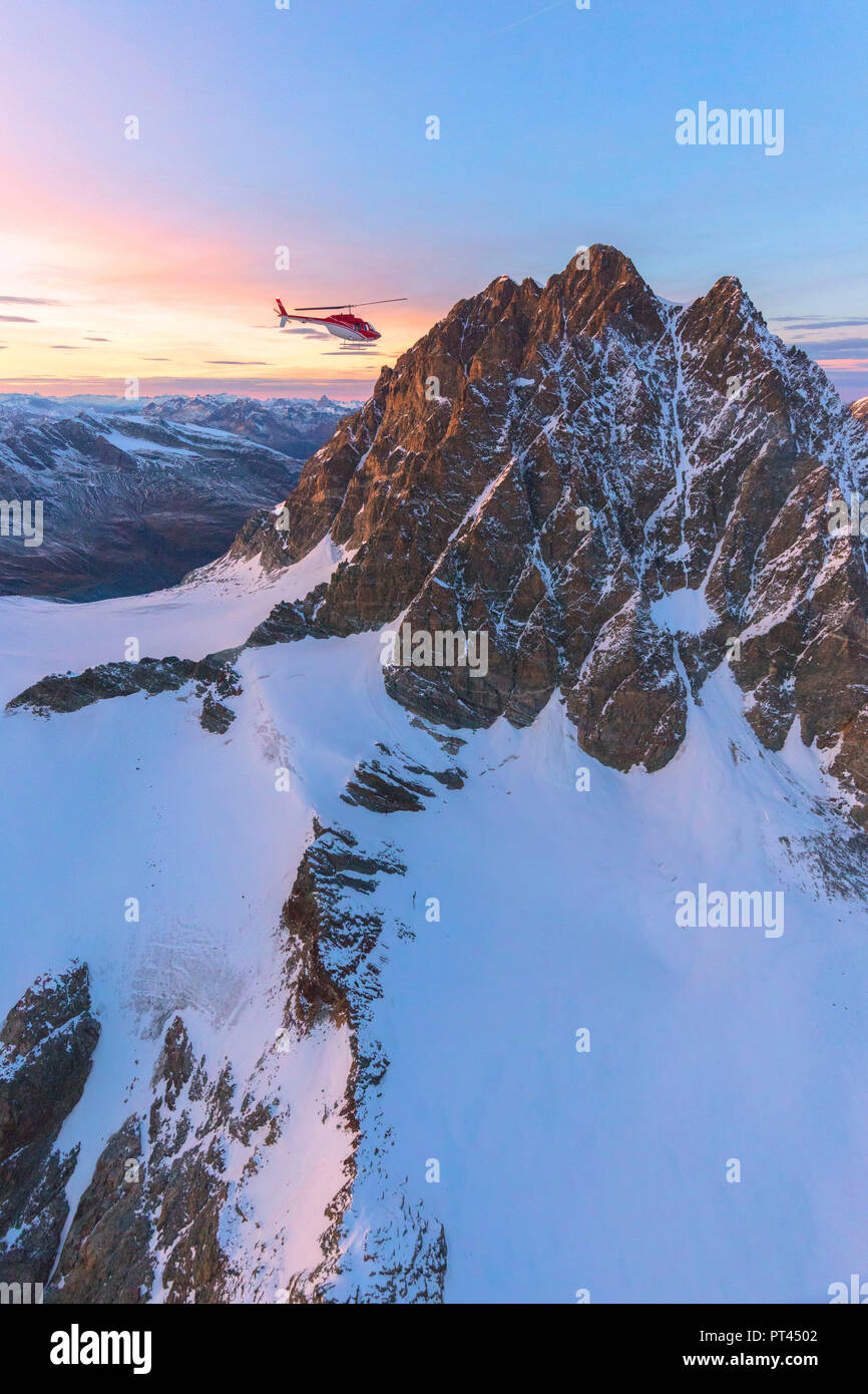 Aerial view of helicopter in flight towards Piz Roseg at sunset ...