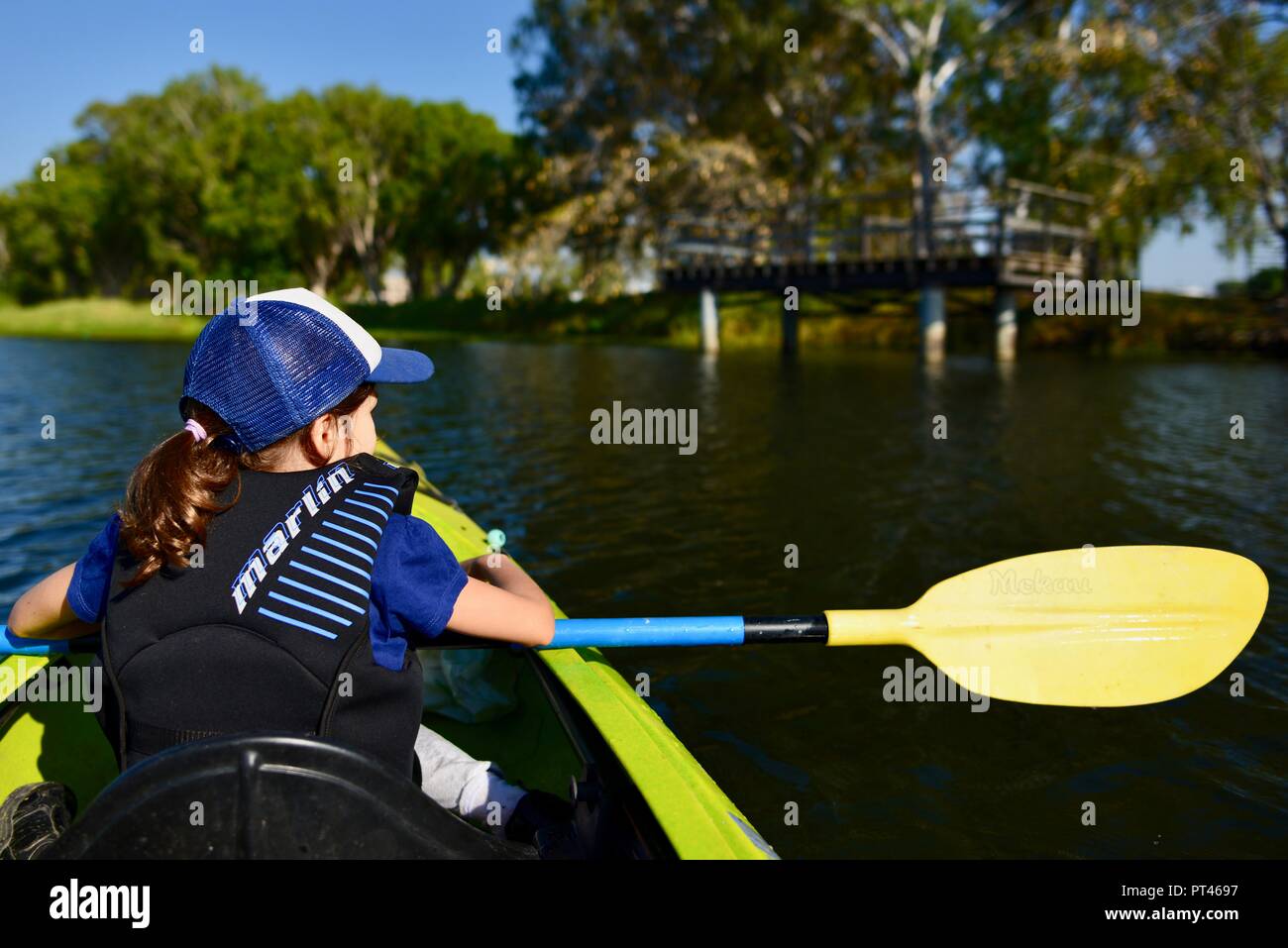 Children paddling in a canoe in beautiful weather, Ross River QLD ...
