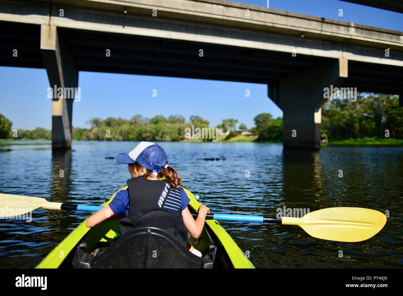 Children paddling in a canoe in beautiful weather, Ross River QLD ...