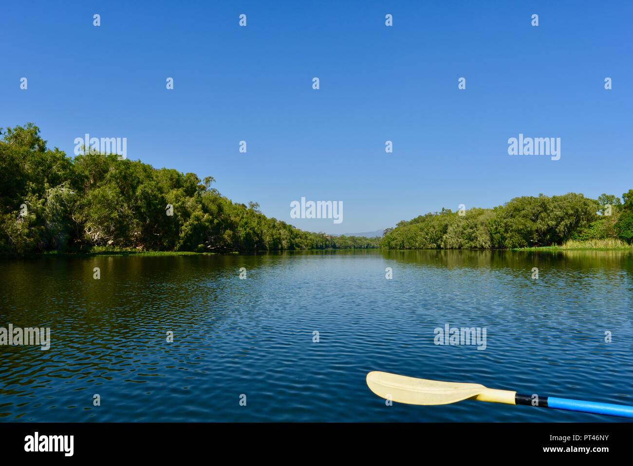 Children paddling in a canoe in beautiful weather, Ross River QLD ...