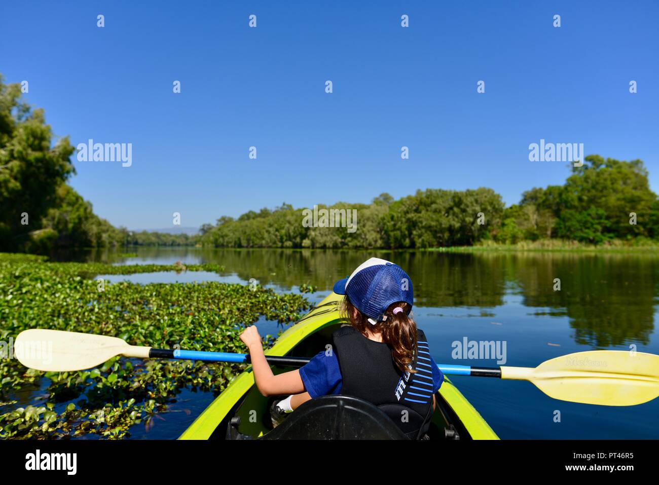 Children paddling in a canoe in beautiful weather, Ross River QLD ...