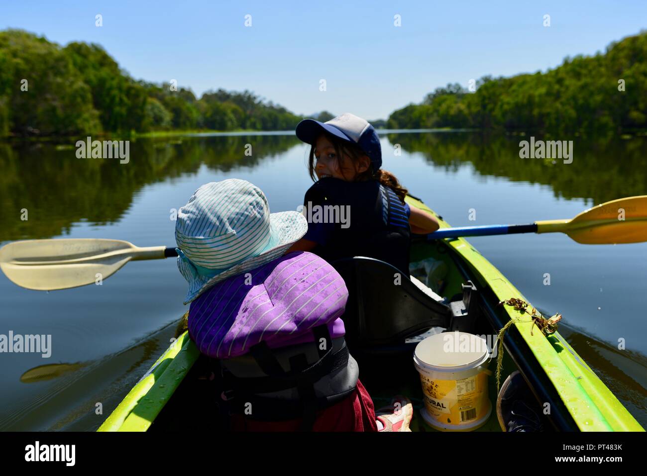 Children paddling in a canoe in beautiful weather, Ross River QLD ...
