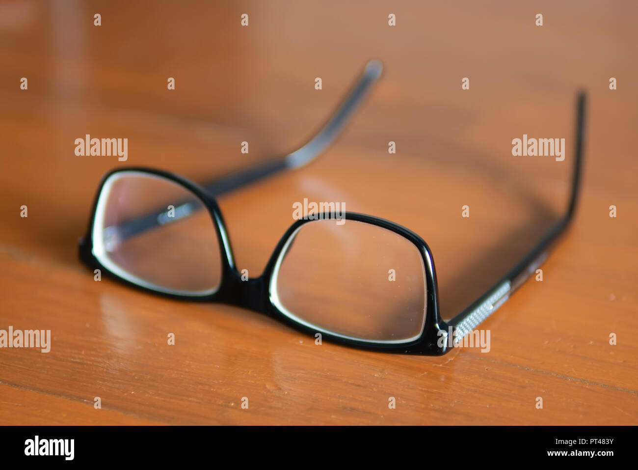 Eyeglasses on wooden table Stock Photo - Alamy