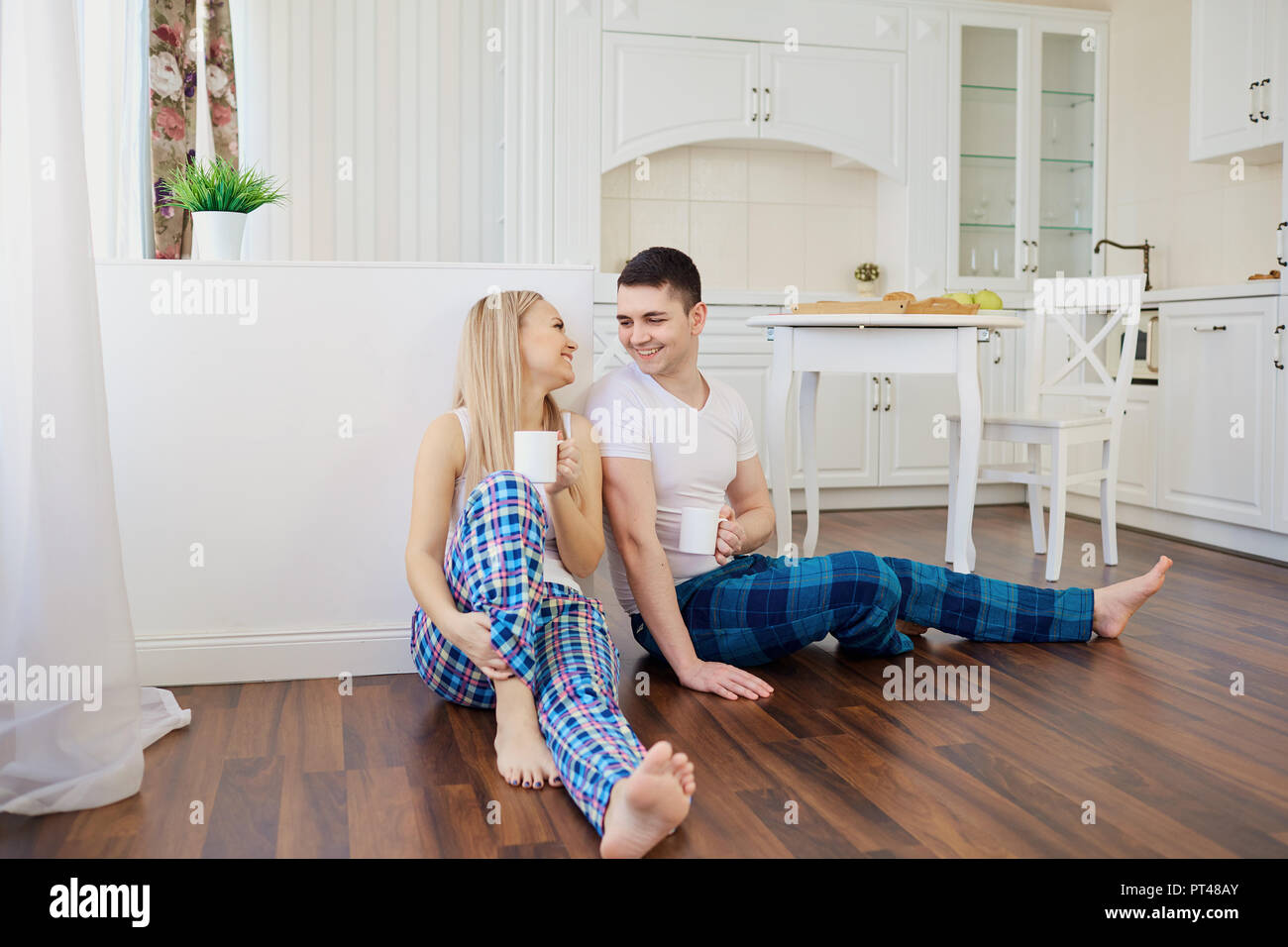 Young couple in the morning embrace in the kitchen Stock Photo - Alamy