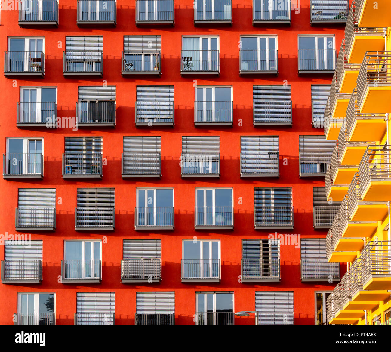 Close up image of two red and yellow high rise buildings with windows ...