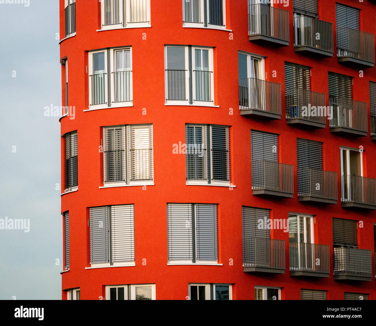 Close up image of red high rise building with windows and balconies and ...