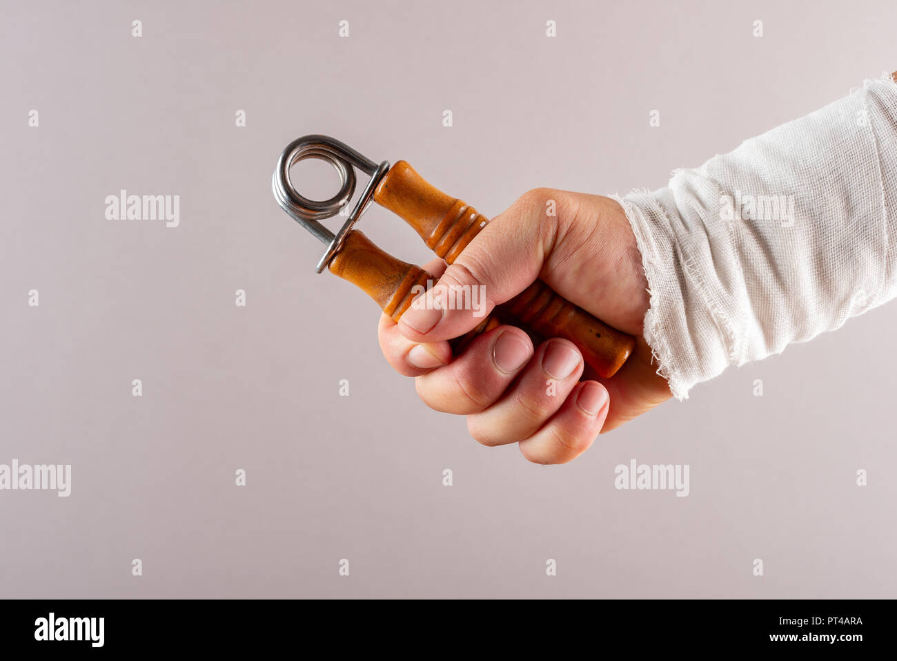 hurt hand doing rehabilitation exercises by squeezing an A shape hand ...