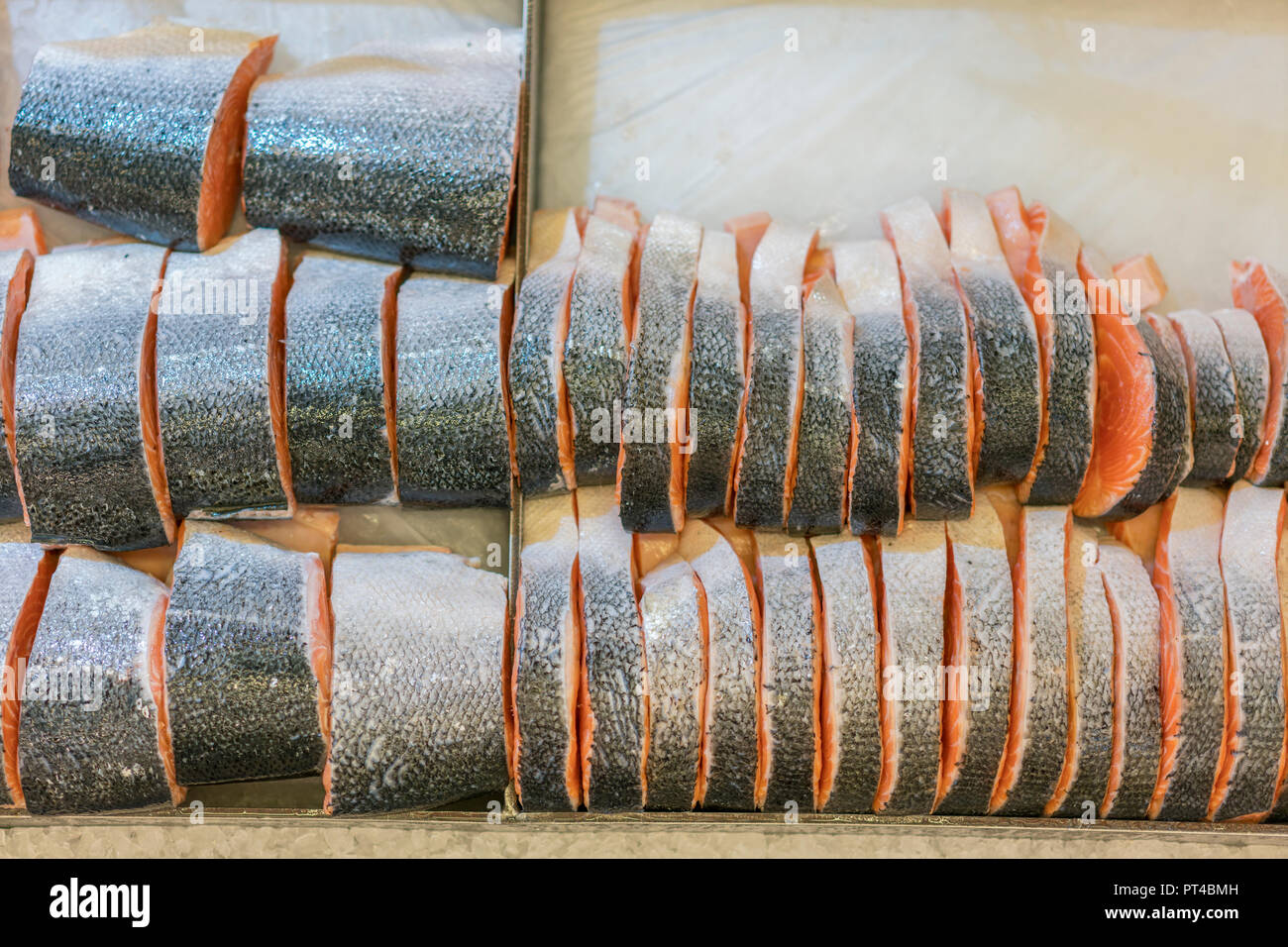 Sliced raw, not cooked salmon, red fish, lying in the ice on the ...