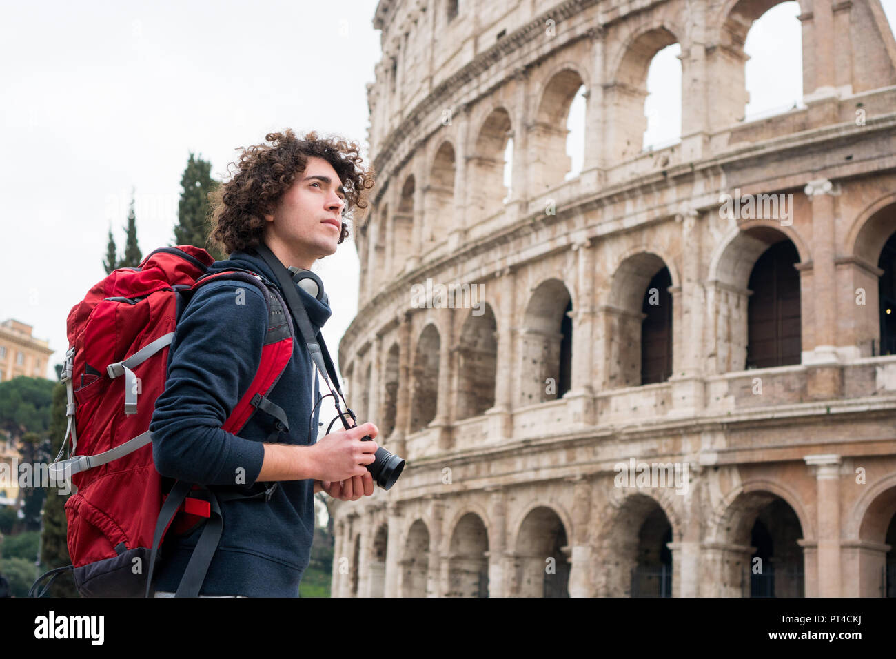 Handsome young tourist man with a camera and backpack taking pictures ...
