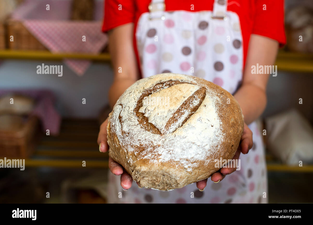Woman in apron shows bread in a bakery Stock Photo - Alamy
