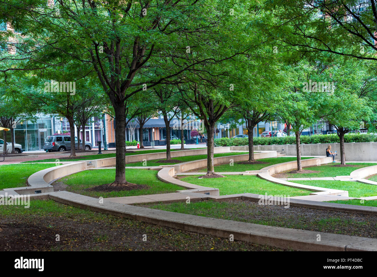 Reston, Virginia--October 2, 2018. A woman sits down in an urban park ...