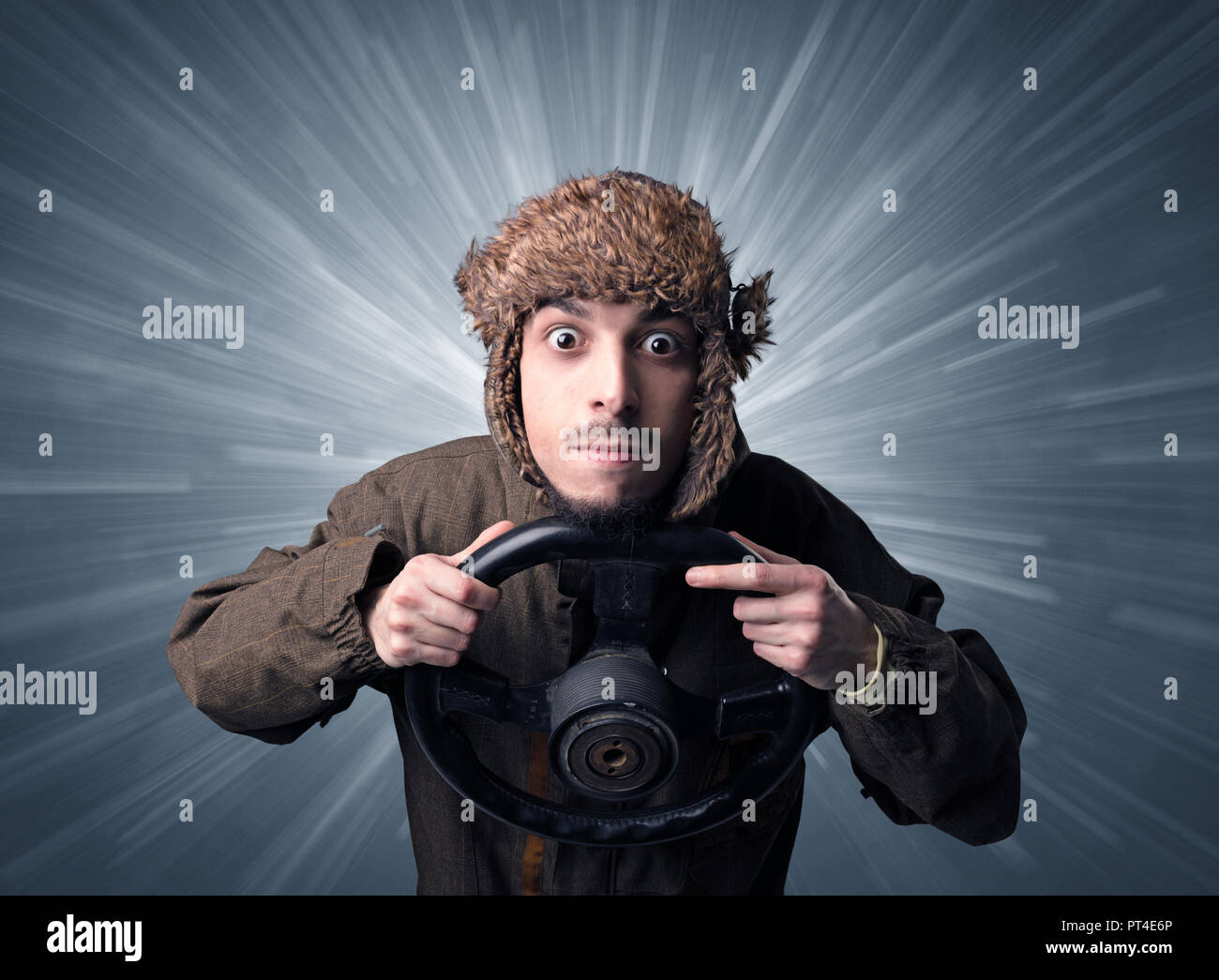 Young man holding black steering wheel with white lines behind him ...