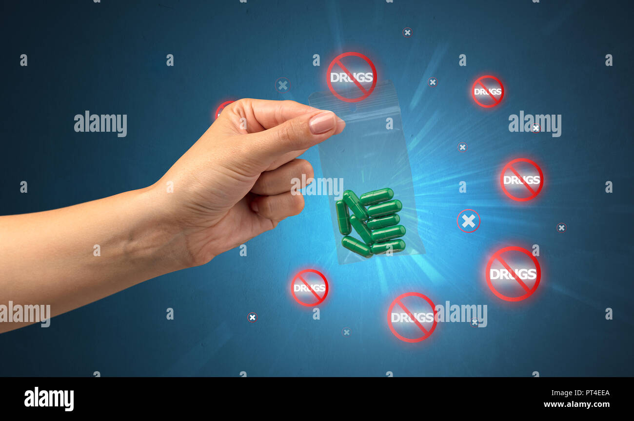 Hand giving pills with anti-drug concept and not allowed signs around ...