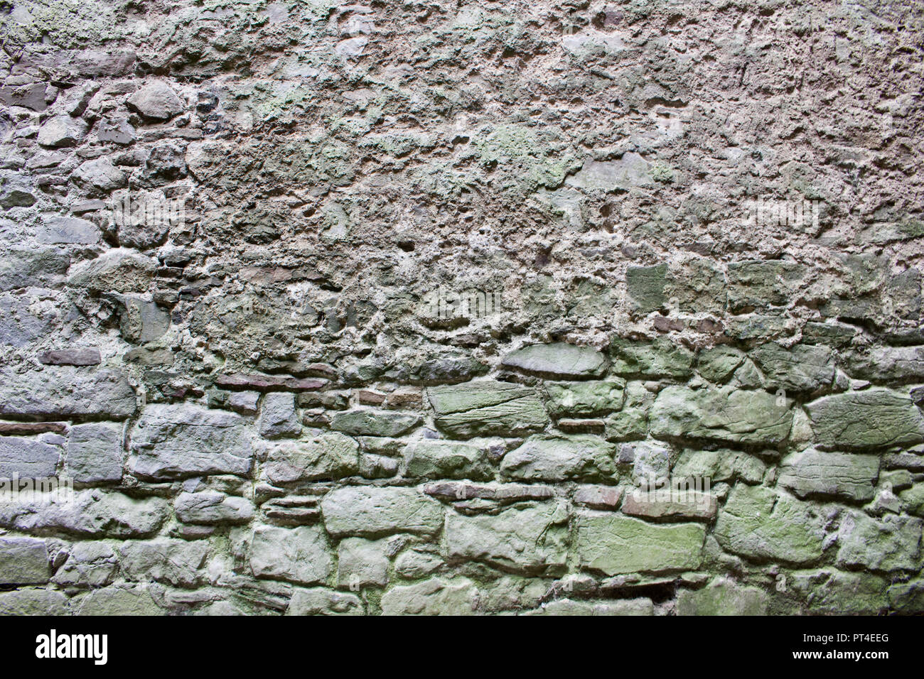 Old gray and brown deteriorating medieval stone wall background with ...