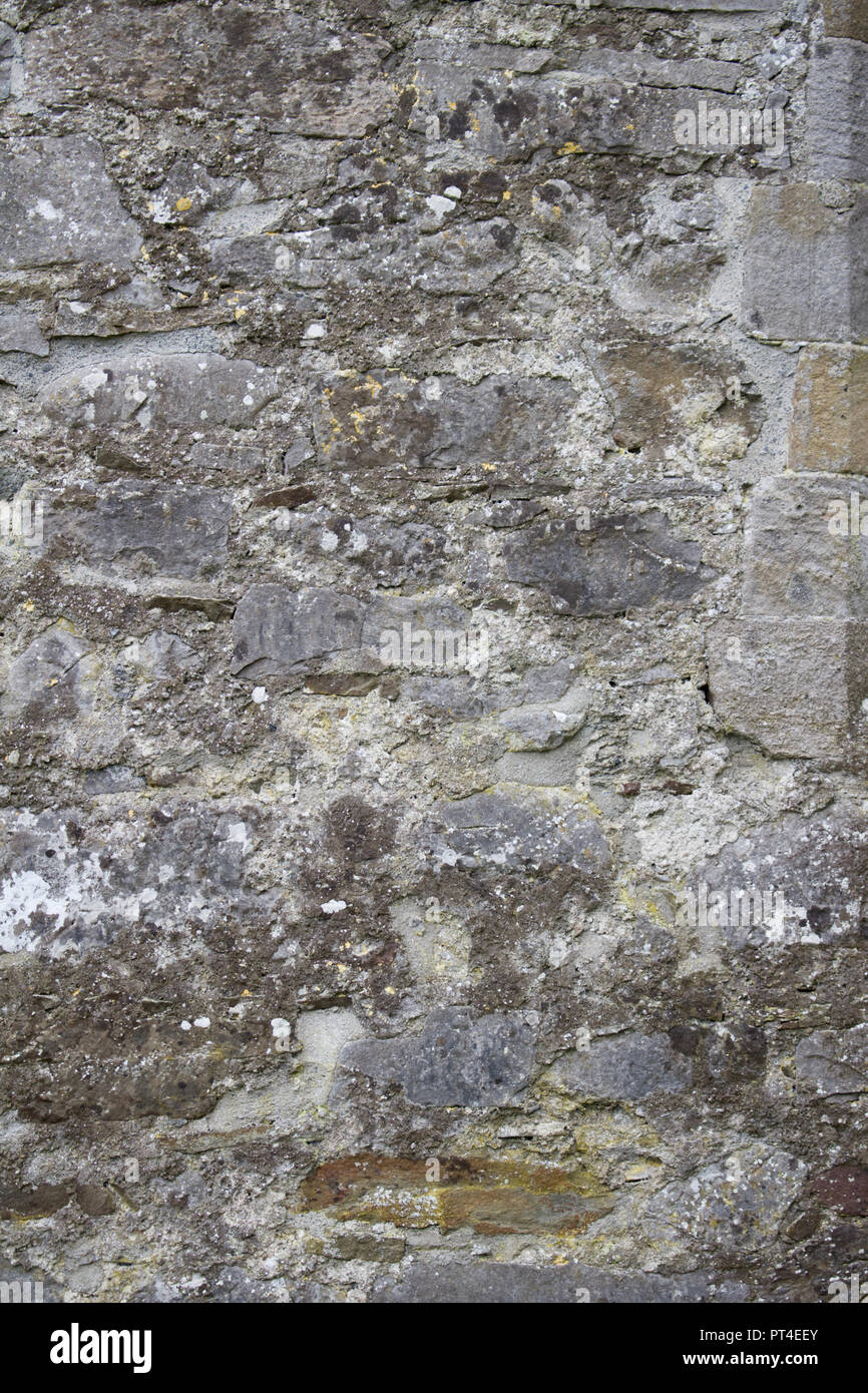 Old gray and brown deteriorating medieval stone wall background with ...