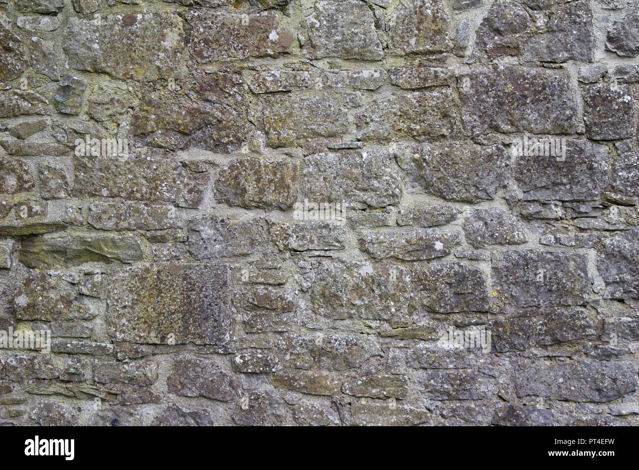 Old gray and brown deteriorating medieval stone wall background with ...