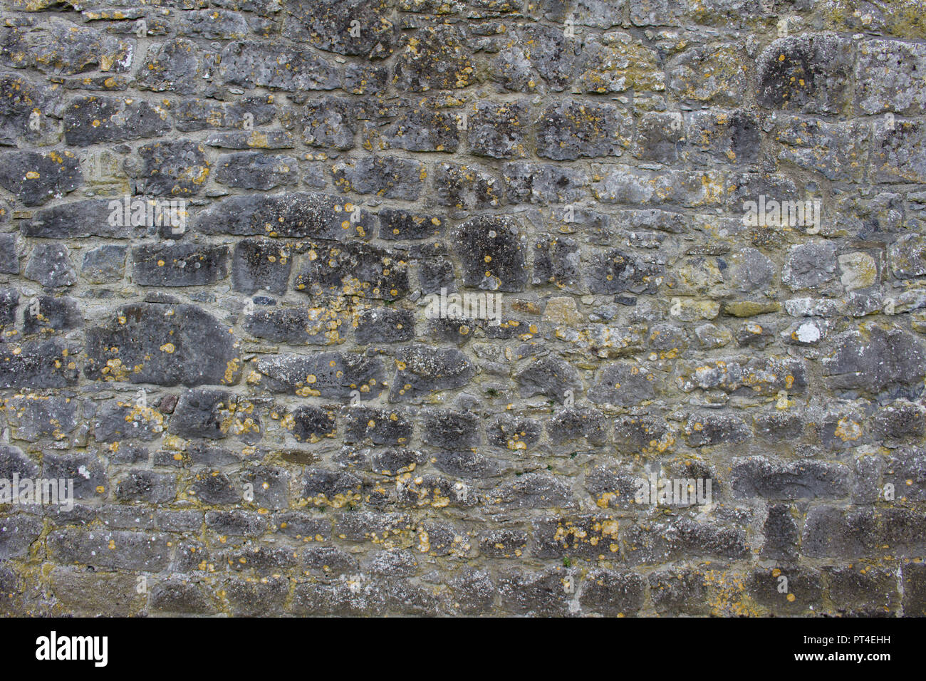 Old gray and brown deteriorating medieval stone wall background with ...