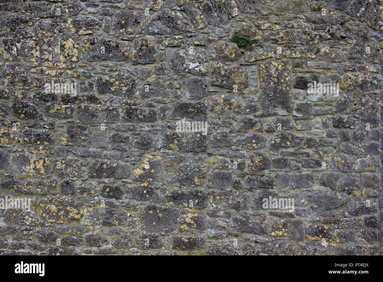 Old gray and brown deteriorating medieval stone wall background with ...