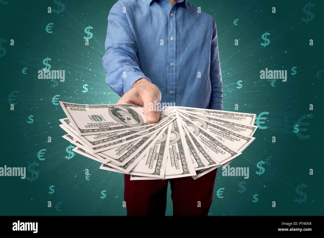 Young businessman holding large amount of bills with green background ...