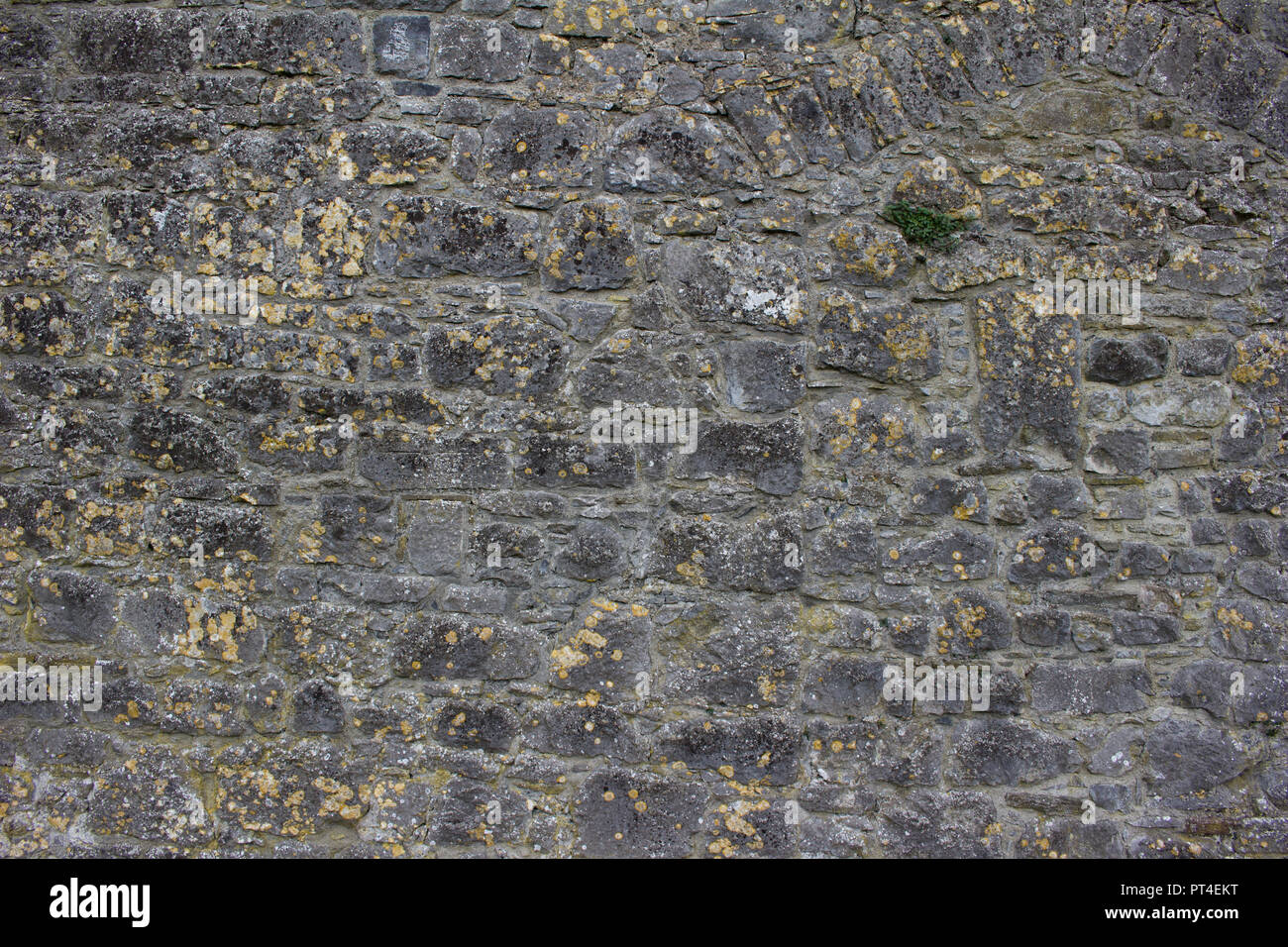 Old gray and brown deteriorating medieval stone wall background with ...