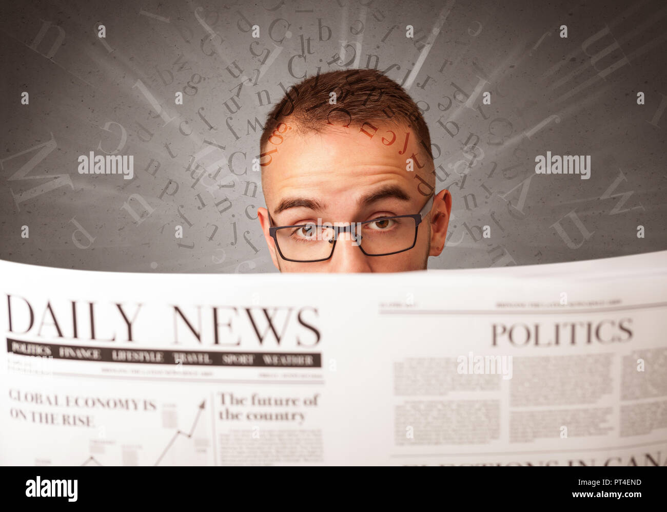 Young smart businessman reading daily newspaper with alphabet letters ...