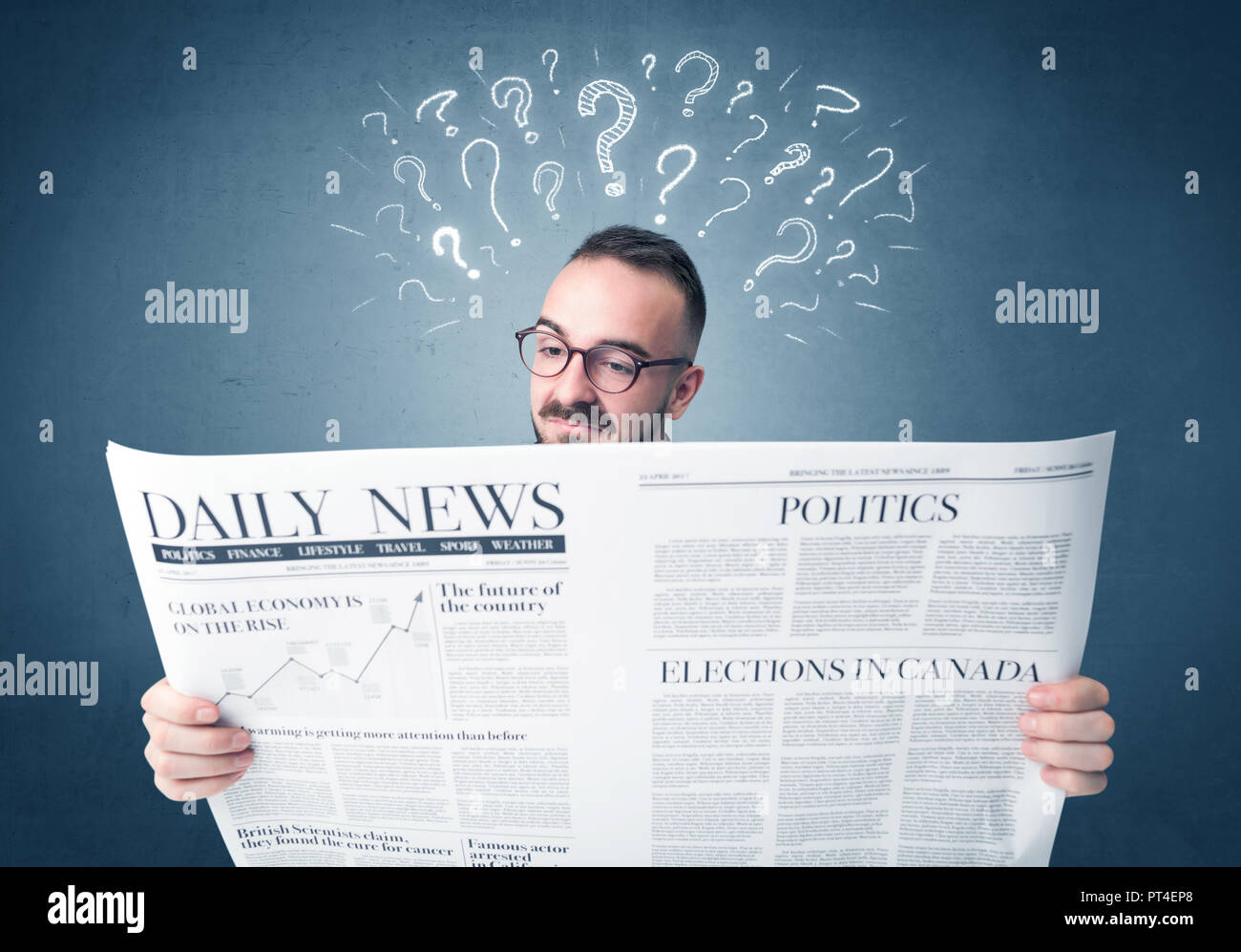 Young confused businessman reading daily newspaper with question marks ...