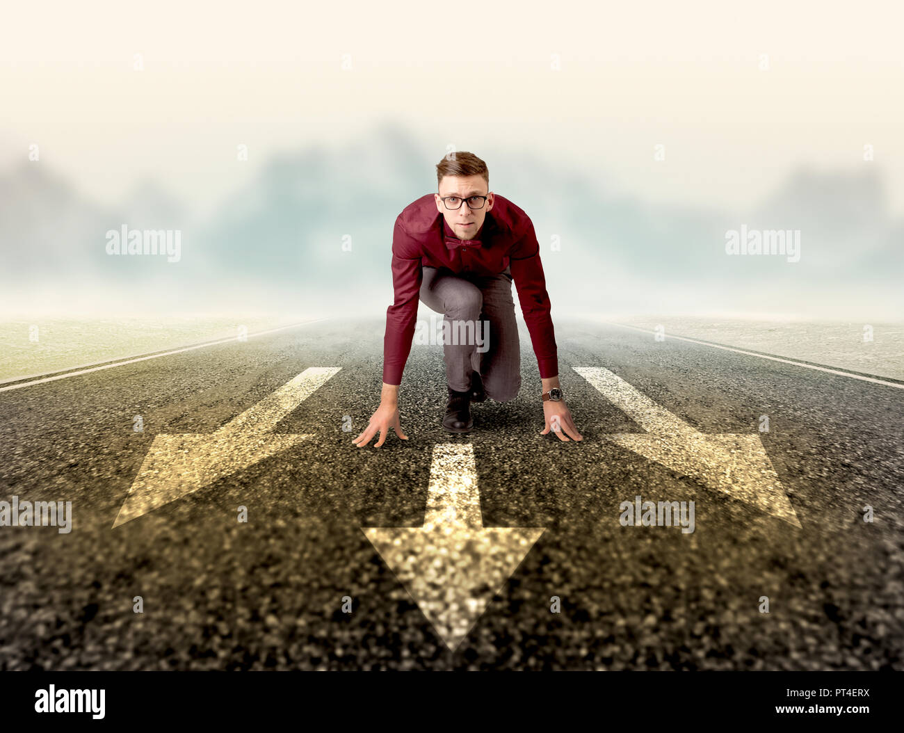Young determined businessman kneeling before three arrows Stock Photo ...