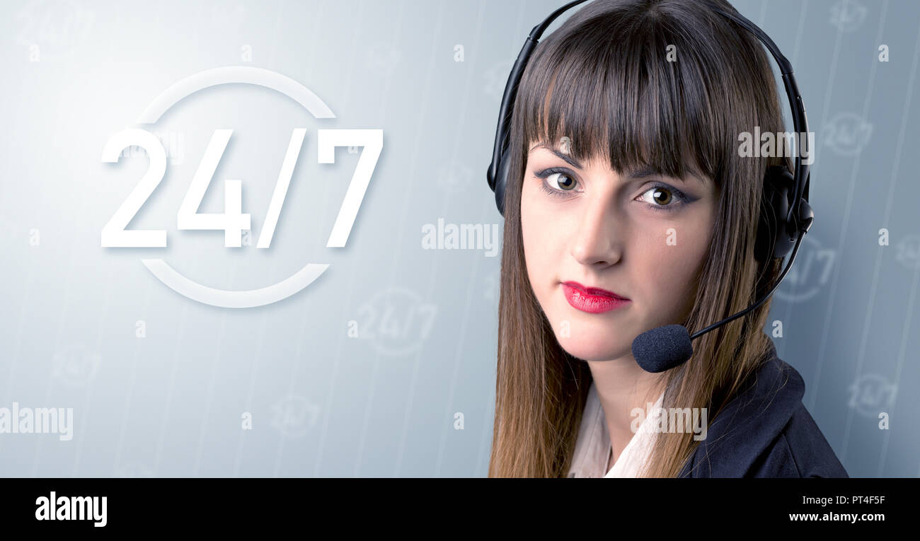 Young female telemarketer with a 24 7 sign next to her Stock Photo - Alamy