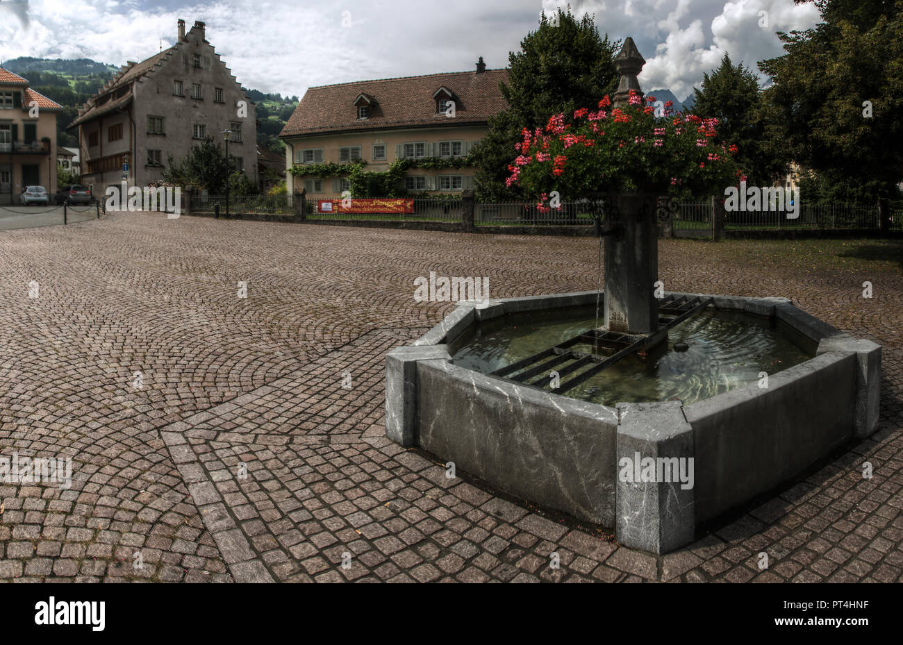 Public fountain and geraniums in Flums Swiss Alps Stock Photo - Alamy