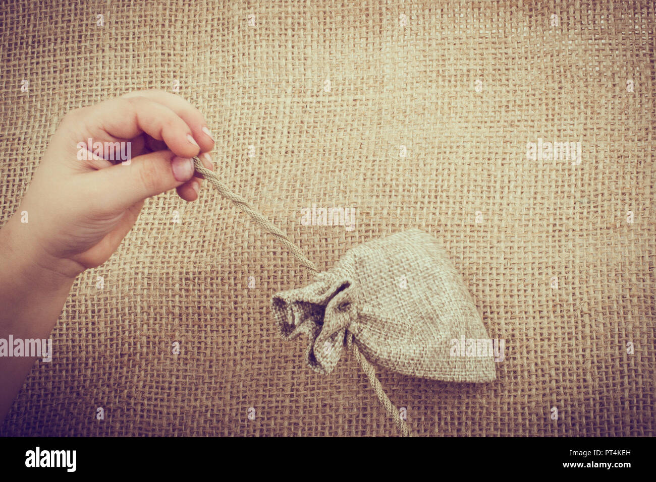 Hand holding an empty little sack made of linen Stock Photo - Alamy