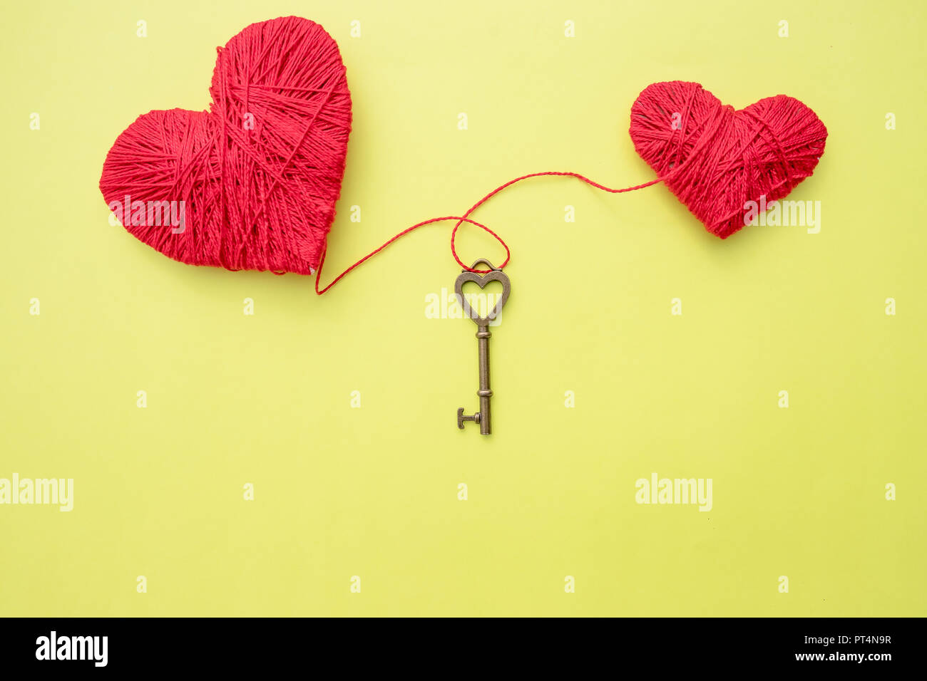 Key with two hearts as a symbol of love on the yelow background. Key of ...