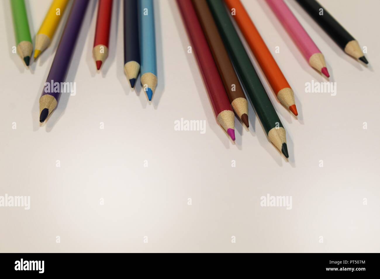 Colored Pencils Scattered across the top of the frame Stock Photo - Alamy